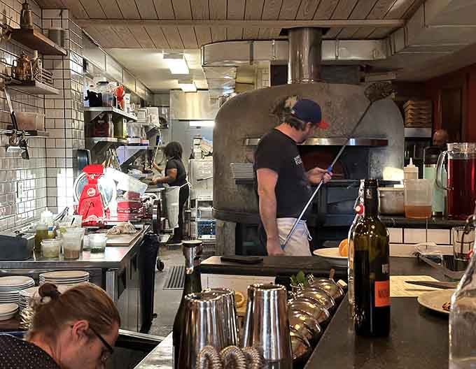 Watch skilled hands work the wood-fired oven, turning simple dough into blistered, leopard-spotted perfection.