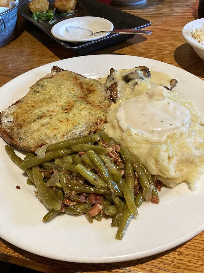 Parmesan-crusted pork chop with all the fixings, because subtlety has no place at this table.