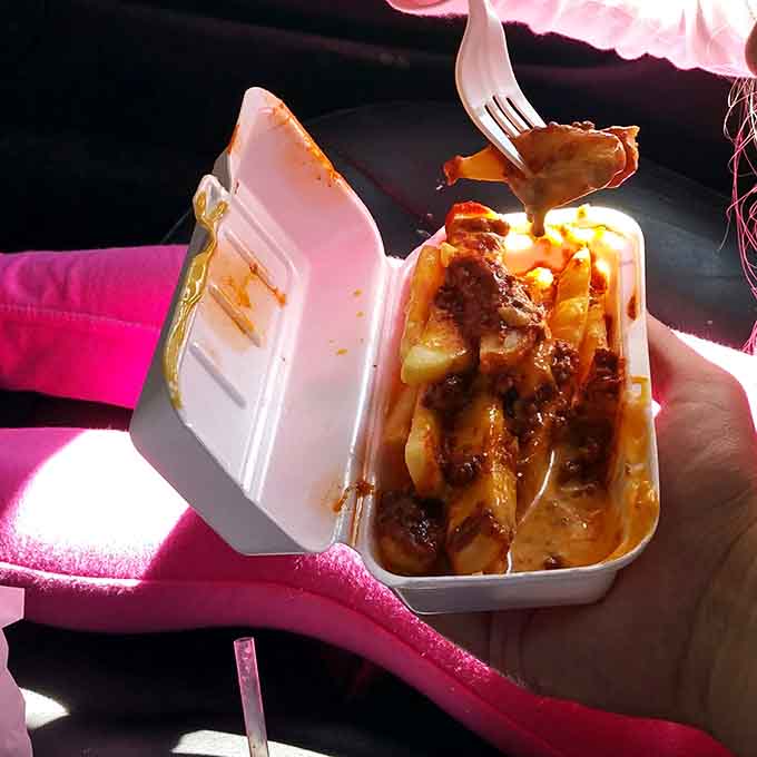 Chili and cheese cascading over crispy fries with a plastic fork at the ready: comfort food reaches its peak.