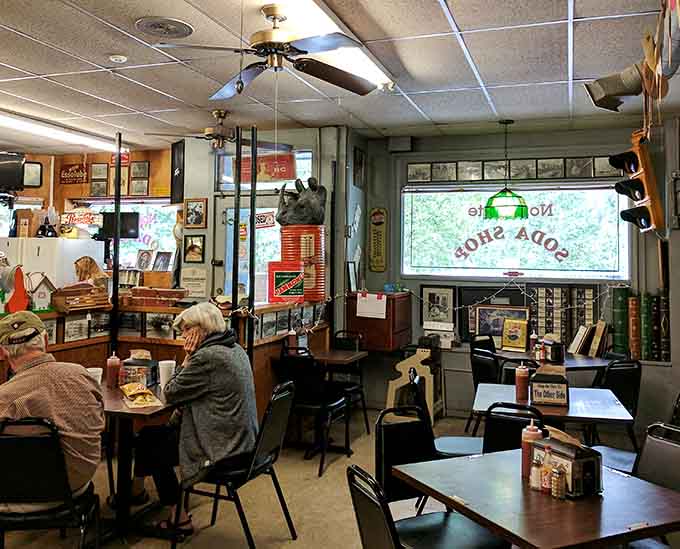 College pennants hanging overhead while diners enjoy their meals, creating that perfect small-town gathering spot atmosphere everyone craves.