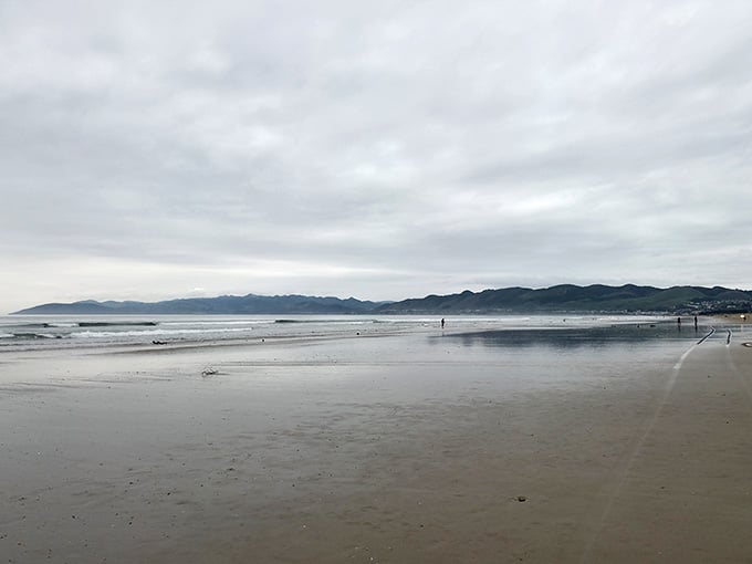 Low tide reveals a mirror-smooth canvas reflecting mountains across the bay.