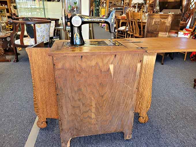 A vintage sewing machine cabinet proving our grandmothers were basically running small manufacturing operations from their living rooms.