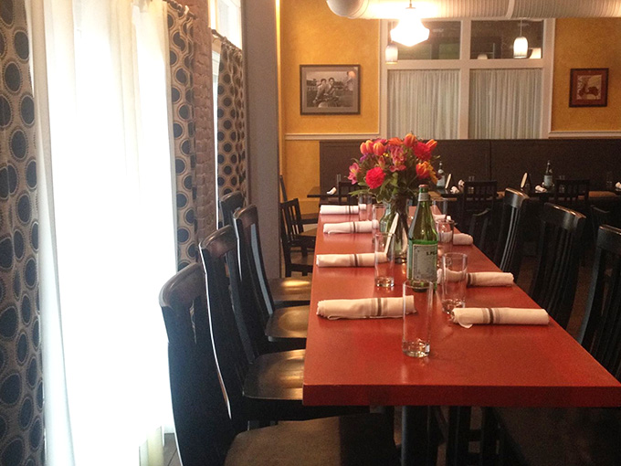 Long communal tables with fresh flowers suggest this place understands that dining is meant to be a shared celebration.