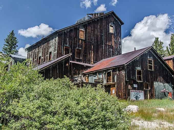 The main structure looms like a wooden cathedral, its weathered boards holding secrets from Colorado's wildest days.