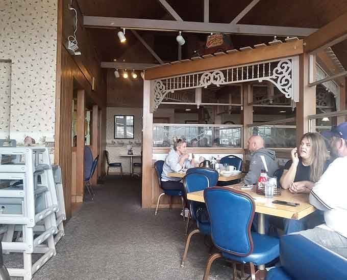 Ornate wooden trim, vaulted ceilings, and blue booths: a dining room with real personality and soul.