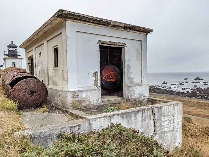 Outbuildings slowly surrender to time and weather, their rusted equipment telling stories of a bygone maritime era.