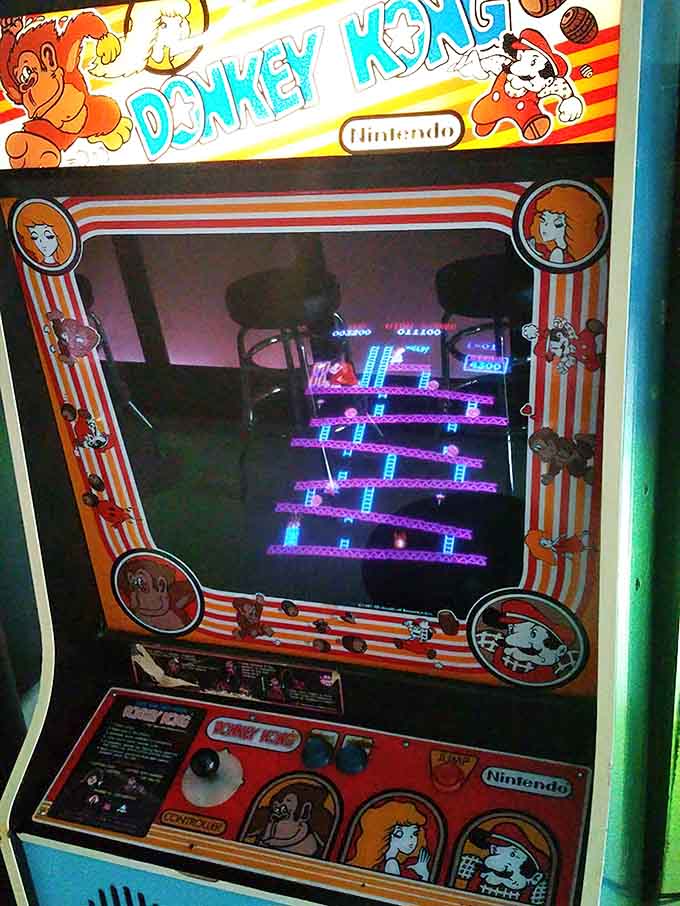 Original Donkey Kong cabinet with Mario climbing those iconic ladders, still challenging players after all these decades.