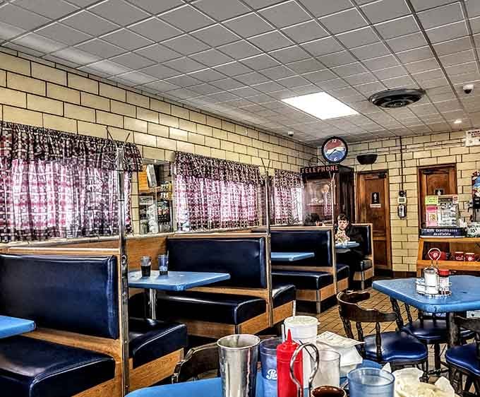 Booth seating with gingham curtains creating that homey atmosphere chain restaurants spend millions trying to fake and failing miserably.