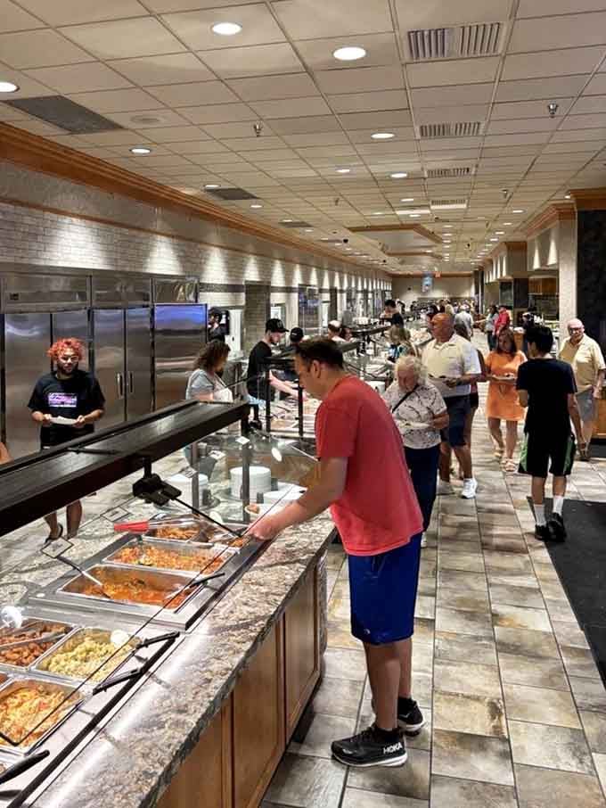 The buffet line stretches endlessly forward, each person plotting their strategic approach to maximum delicious consumption ahead.