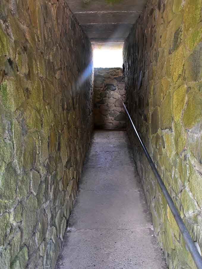 The narrow stone stairway beckons upward toward brilliant light, each step bringing you closer to panoramic rewards above.