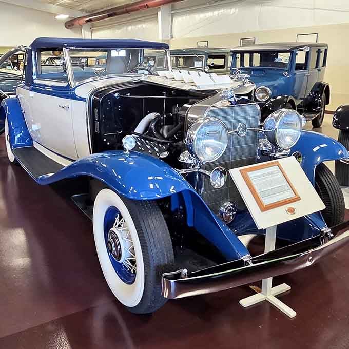 This blue and white stunner with its exposed engine looks like it just rolled off a 1930s movie set.