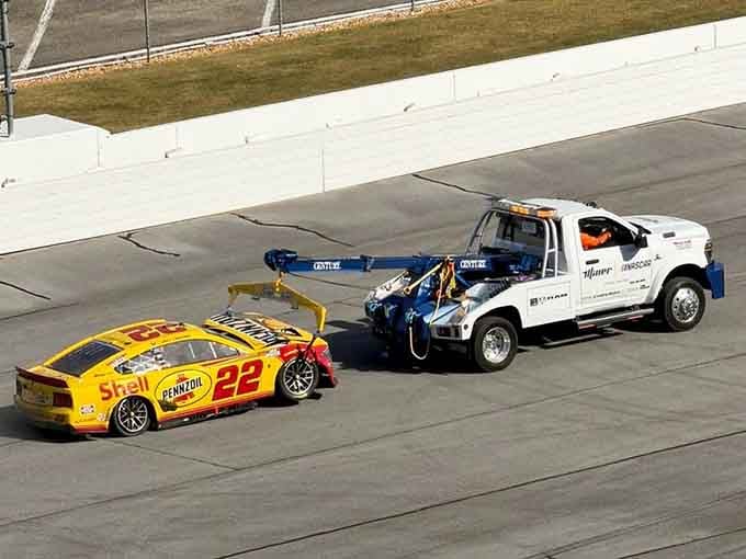 Even broken race cars get the royal treatment here, because every machine deserves a dignified exit from the battlefield.