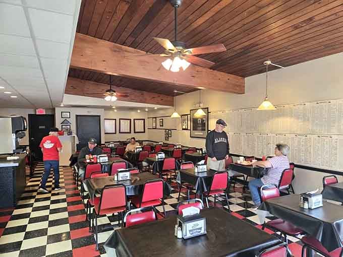 Red chairs on checkered floors create that timeless diner aesthetic where everyone feels welcome and hungry.