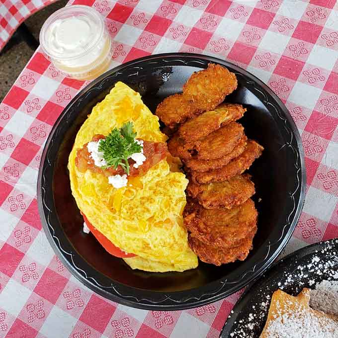 That omelet looks fluffy enough to use as a pillow, paired with crispy fried chicken for a breakfast that means business.