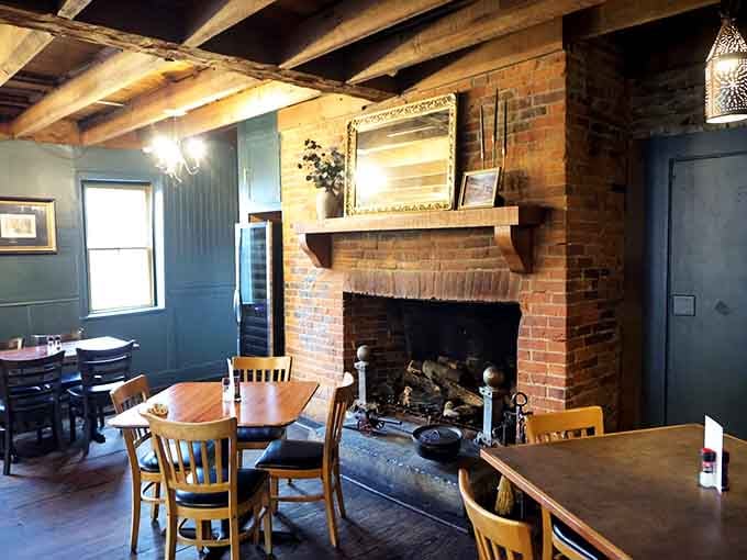 A brick fireplace anchors the dining room, adding warmth that goes beyond temperature into pure welcoming hospitality and ambiance.