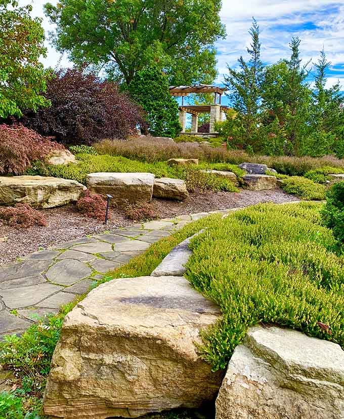 Stone pathways winding through gardens that make your backyard look like it needs a pep talk.