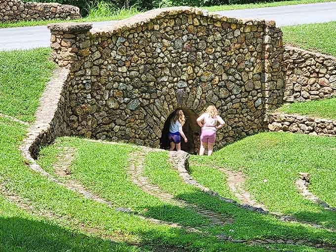 Kids peek through the stone grotto's archway, discovering that sometimes the best playgrounds don't have plastic slides at all.