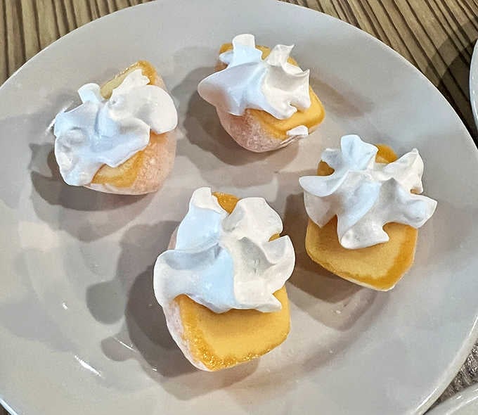 Delicate lemon meringue bites topped with clouds of sweetness, the perfect finale after your seafood marathon session.