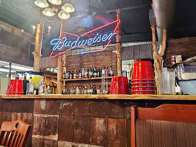 That rustic bar with its neon Budweiser sign and red buckets stacked high exudes genuine honky-tonk charm.