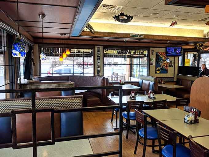 Blue vinyl booths and wooden tables create classic diner comfort while Batman keeps watch from every available surface.