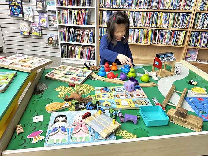 Little hands explore educational toys surrounded by shelves of stories, making learning feel like pure playtime magic.