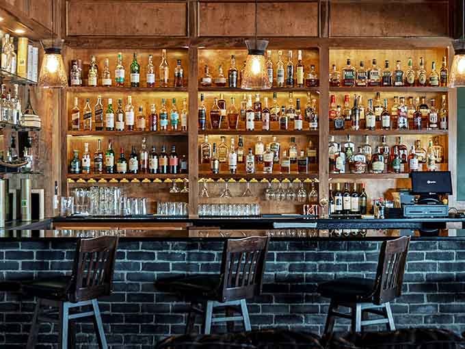A well-stocked bar backed by warm wood and brick: the kind of setup that whispers possibilities.