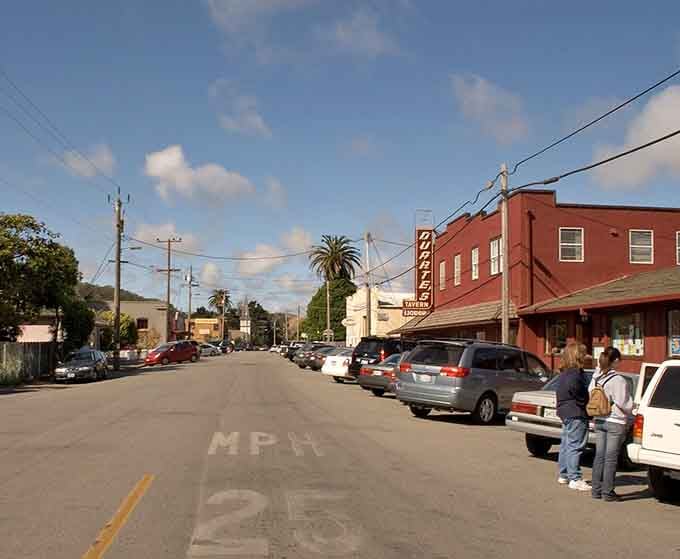 The main drag stretches toward green hills, where palm trees remind you California's diversity never stops surprising.
