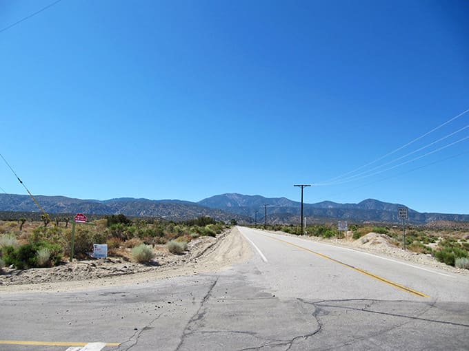Desert straightaways offer breathing room between mountain curves, where distant peaks beckon you ever onward.