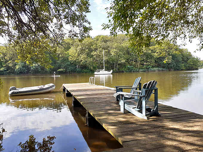 Peaceful dock with Adirondack chairs positioned perfectly for contemplating life's important questions, like dinner plans.