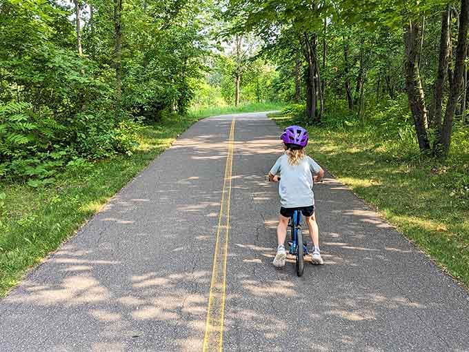 Paved trails welcome young cyclists learning that balance thing while parents jog behind offering unnecessary advice constantly.