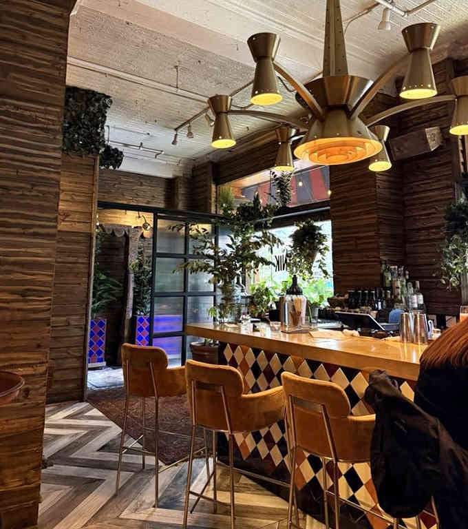A bar area where geometric patterns meet mid-century lighting, proving that sometimes more is more and that's perfectly fine.