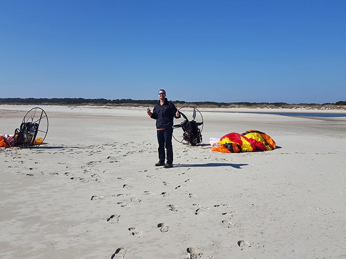 Some adventurous souls arrive by powered paraglider, because apparently walking wasn't dramatic enough for their entrance.