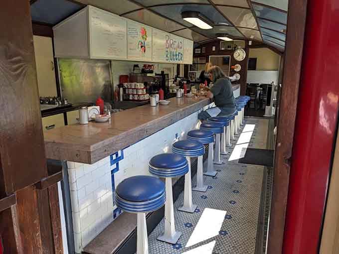 Classic diner counter with blue vinyl stools&mdash;the kind of setup where regulars claim their spots like parking spaces.