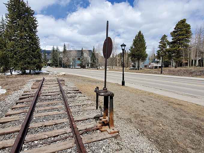 Original track and switching equipment line the roadside, offering authentic details that model train enthusiasts absolutely treasure and photograph obsessively.