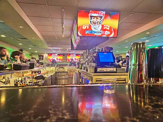 The bar area gleams with promise, multiple screens overhead ensuring you can watch the game while enjoying your favorite cold beverage.