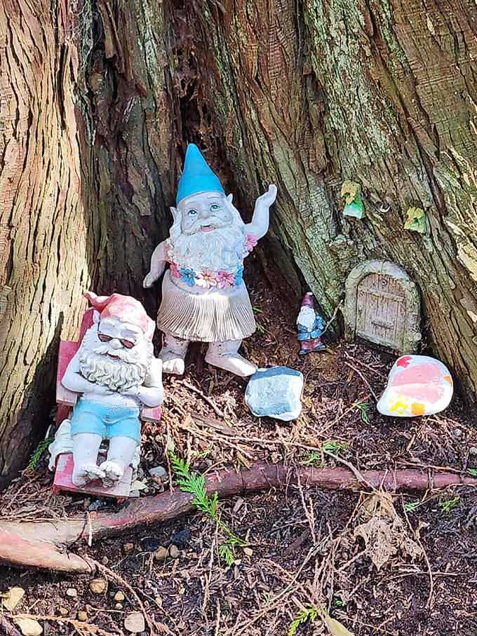 Beach-casual gnomes lounge in their tree hollow, sporting Hawaiian shirts and proving retirement looks good on everyone.