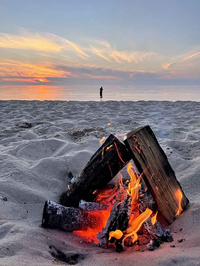 A crackling bonfire at sunset turns a great beach day into an unforgettable evening under painted skies.