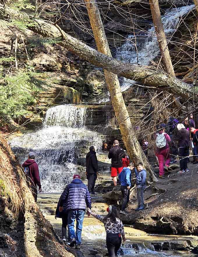Fellow explorers cluster around the phenomenon, cameras ready to capture proof that fire really does burn behind water.