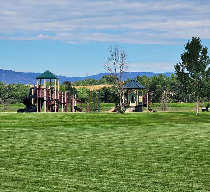 Kids' playground equipment sits against mountain backdrops so stunning you almost forget you're at a regular park and not a resort.