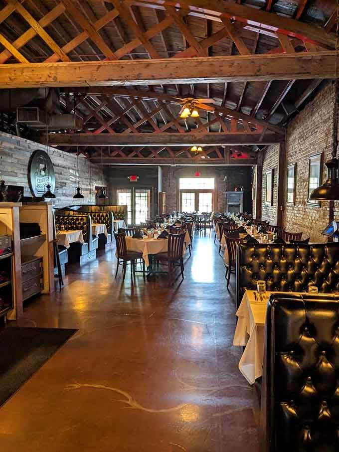 The dining room stretches invitingly toward natural light, blending industrial charm with comfortable elegance throughout.