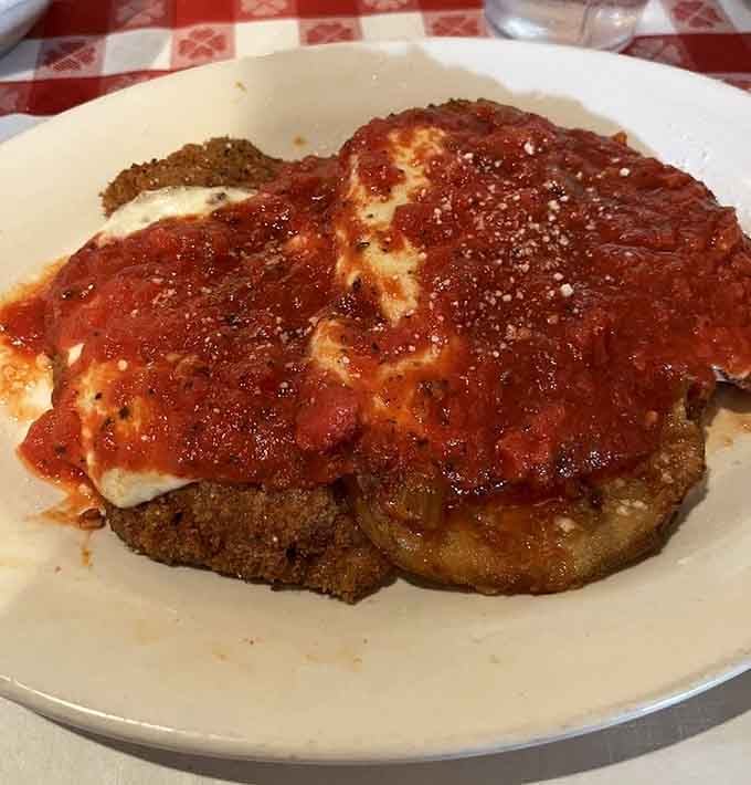 Veal and eggplant parmigiana stacked high with cheese and sauce, looking like an Italian grandmother's proudest achievement.