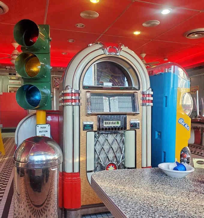 A working jukebox flanked by vintage gas pumps and traffic lights, because why choose just one nostalgic element?