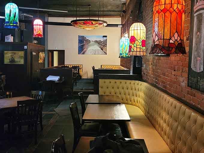 Tufted yellow banquettes and colorful stained glass create an unexpectedly charming atmosphere for coastal cuisine enjoyment.