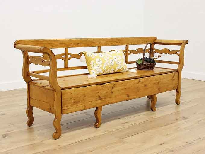 A warm pine settee bench with carved details, simple, honest, and built to outlast everything you own.