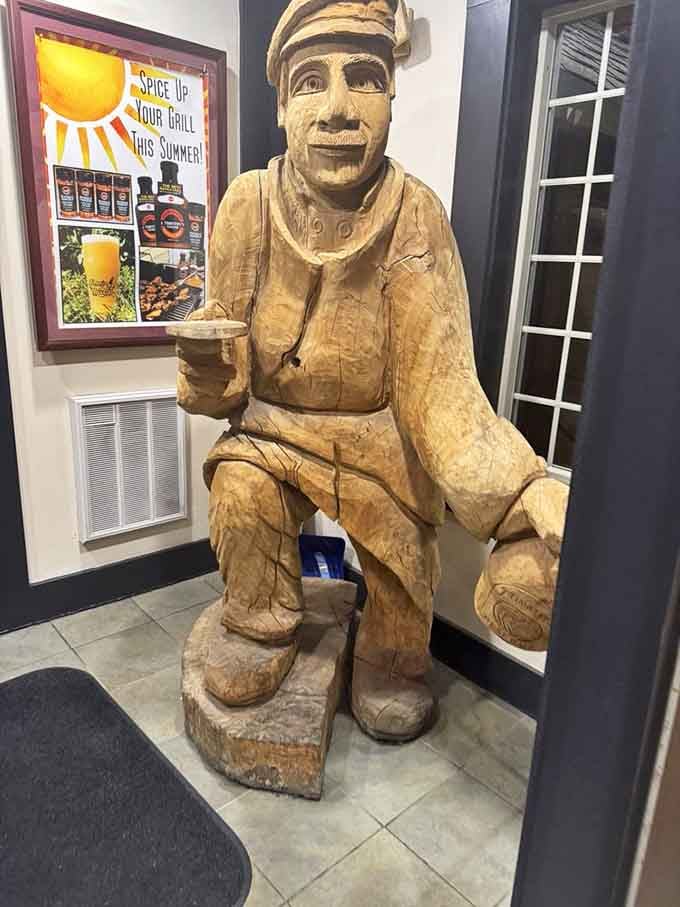 Even the wooden statue knows the secret to happiness: a cold beer and good company nearby.