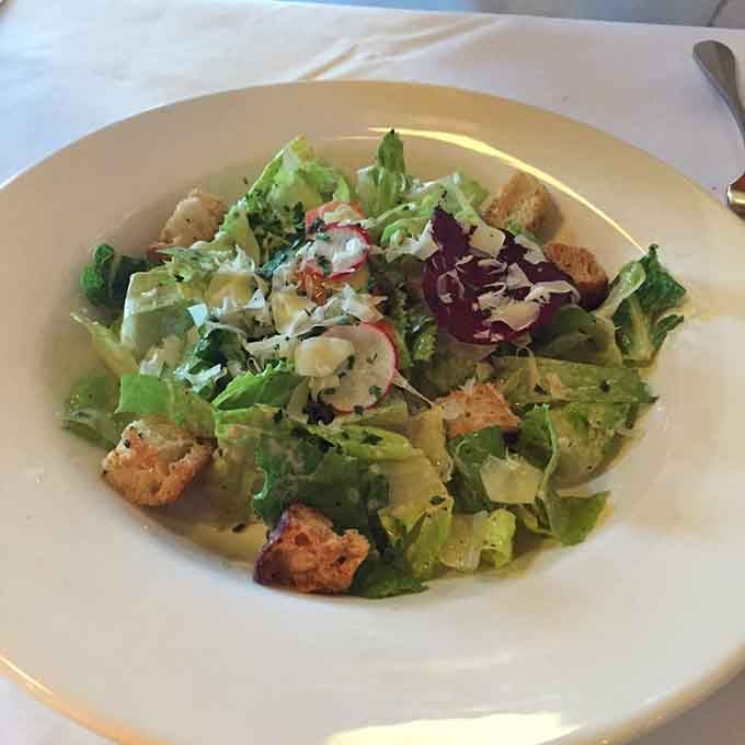 Fresh greens, crispy croutons, and shaved cheese make this Caesar salad look like a garden party on a plate.