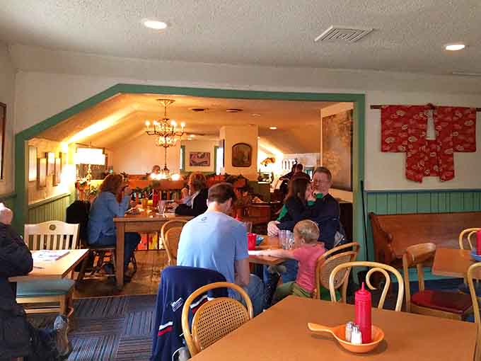 Mismatched chairs and tables create the kind of cozy dining space where strangers become friends over shared breakfast enthusiasm.