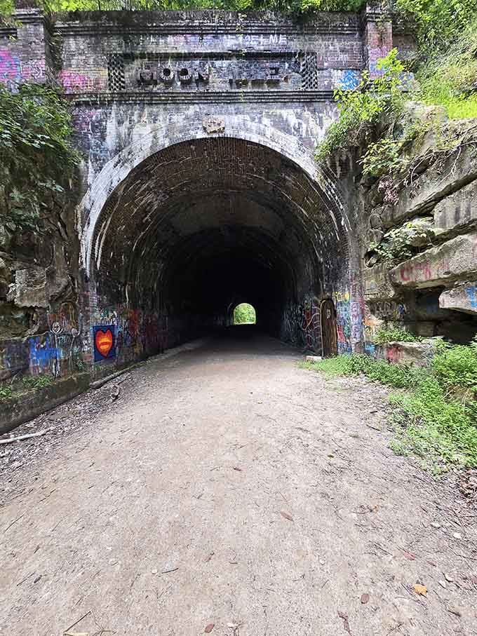 The tunnel's imposing entrance from below reveals layers of brick, graffiti, and history all competing for your attention.