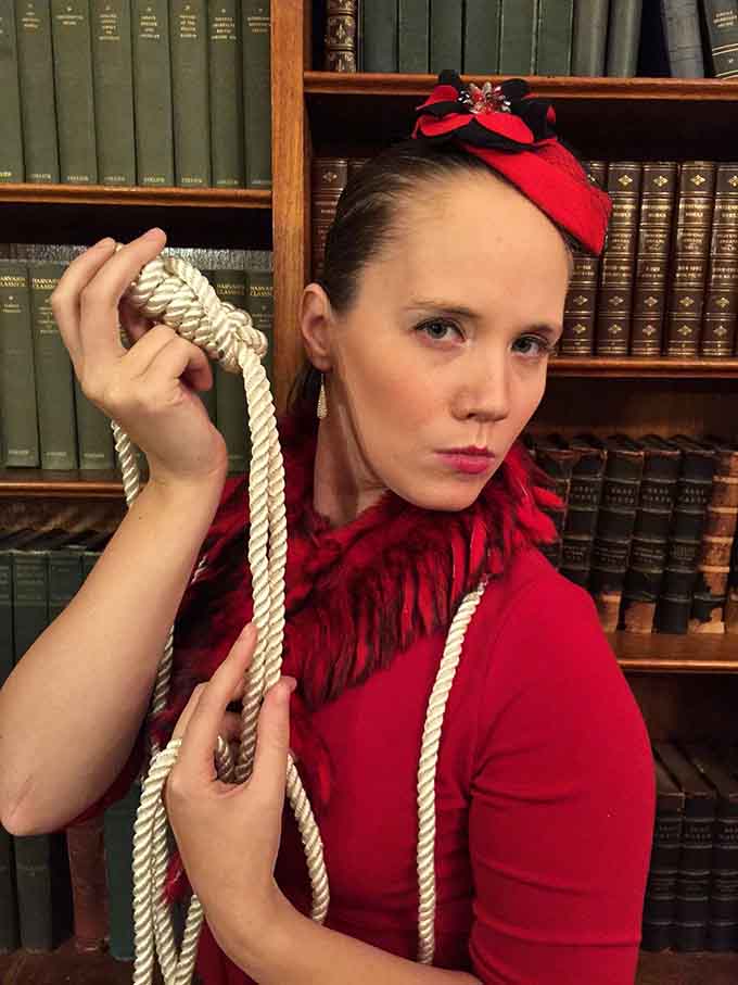 She's holding that rope with suspicious confidence, making you wonder if she's the victim or the villain.
