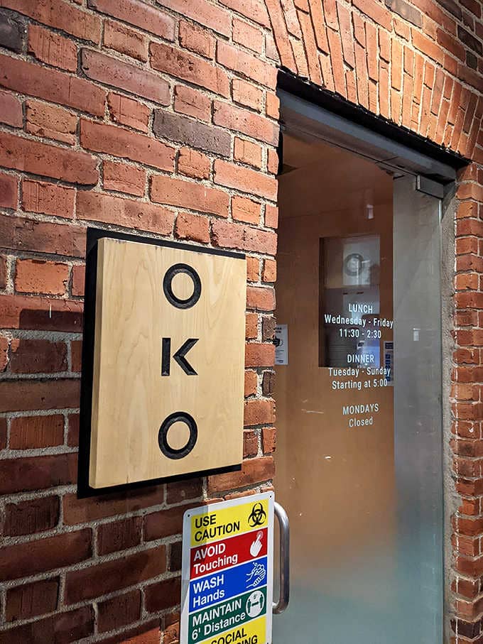 The simple wooden sign on century-old brick whispers sophistication while promising the culinary adventure waiting inside for you.